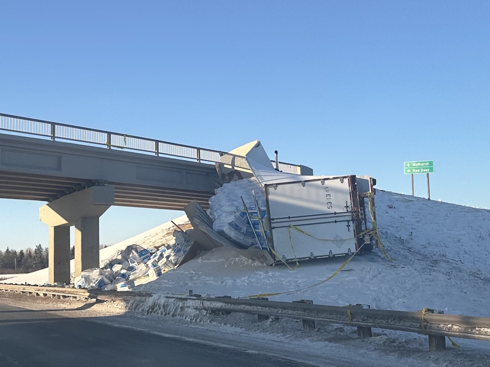 Semi flips, loses product underneath QEII overpass ...